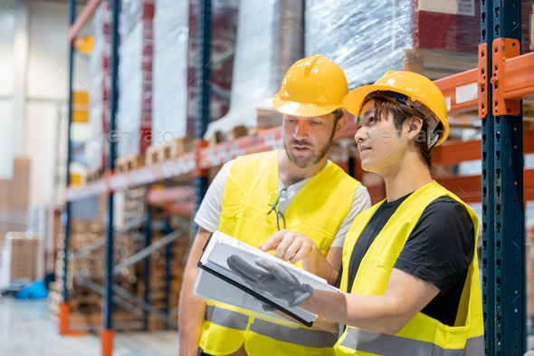 Warehouse workers looking on documents and checking list of packages ...