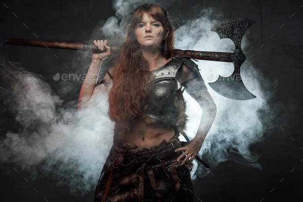 Holding two handed axe northern female warrior in dark background Stock Photo by fxquadro