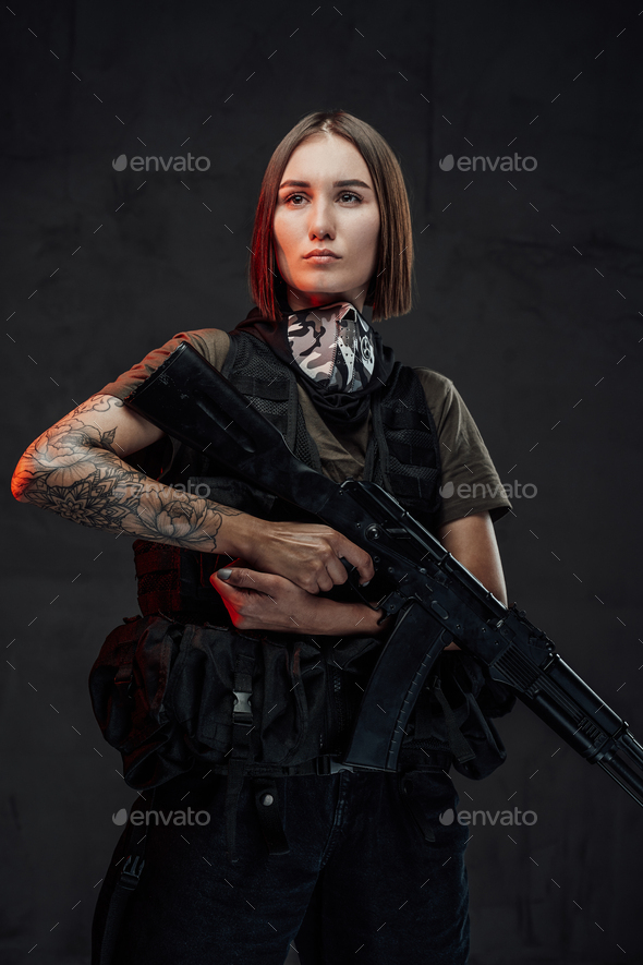 Cheerful female mercenary with assault rifle in dark background Stock ...
