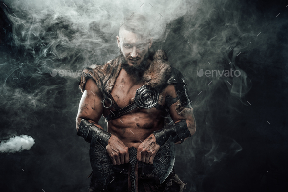 Nordic barbarian in light armour in smokey background with axe Stock ...