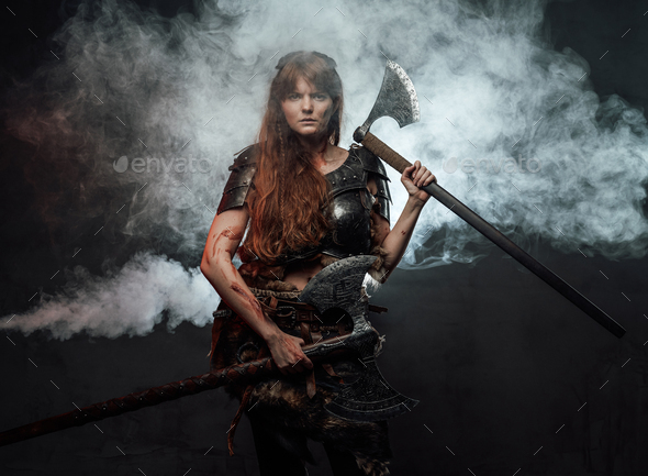 Angry northern amazon wielding two axes in smokey background Stock ...