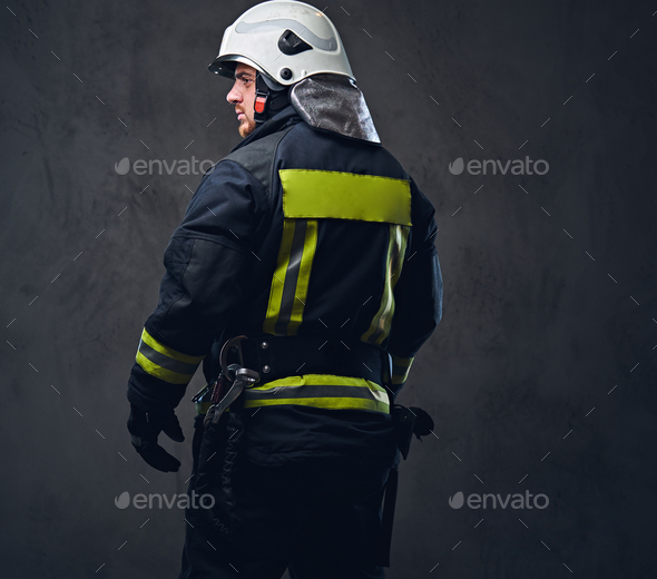 Studio portrait of firefighter dressed in uniform. Stock Photo by fxquadro