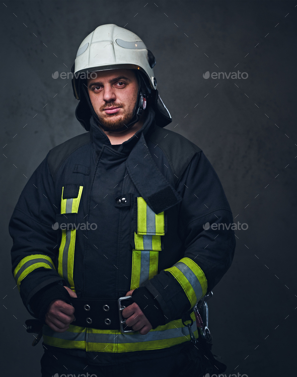 Studio portrait of firefighter dressed in uniform. Stock Photo by fxquadro