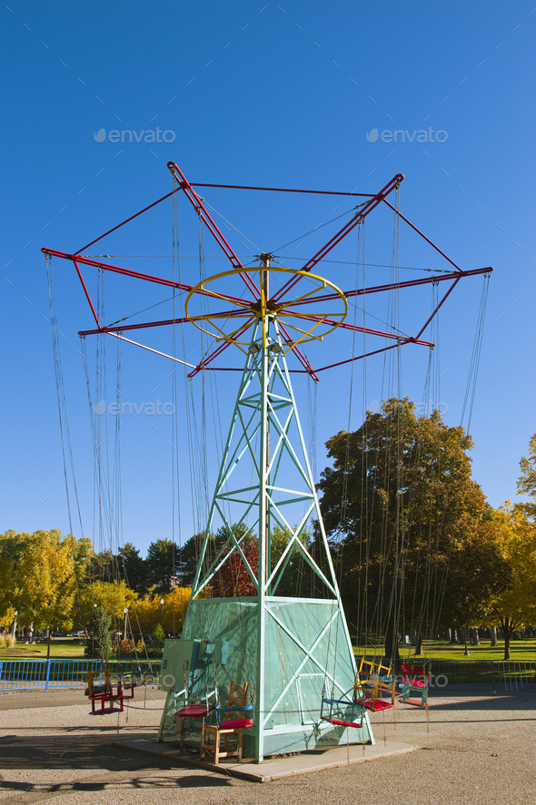 Merry go round in a park with suspended seating. Stock Photo by Mint_Images