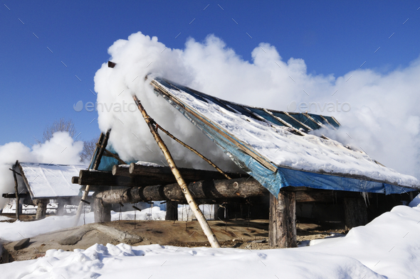 Wooden shack covered with clouds in snow. Stock Photo by Mint_Images
