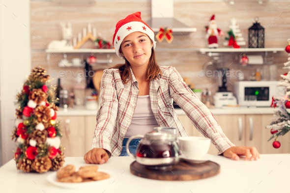 Joyful girl wearing santa heat celebrating christmas in kitchen Stock ...
