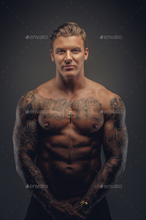 Fashinable muscular man with tattooes on grey background Stock Photo by ...