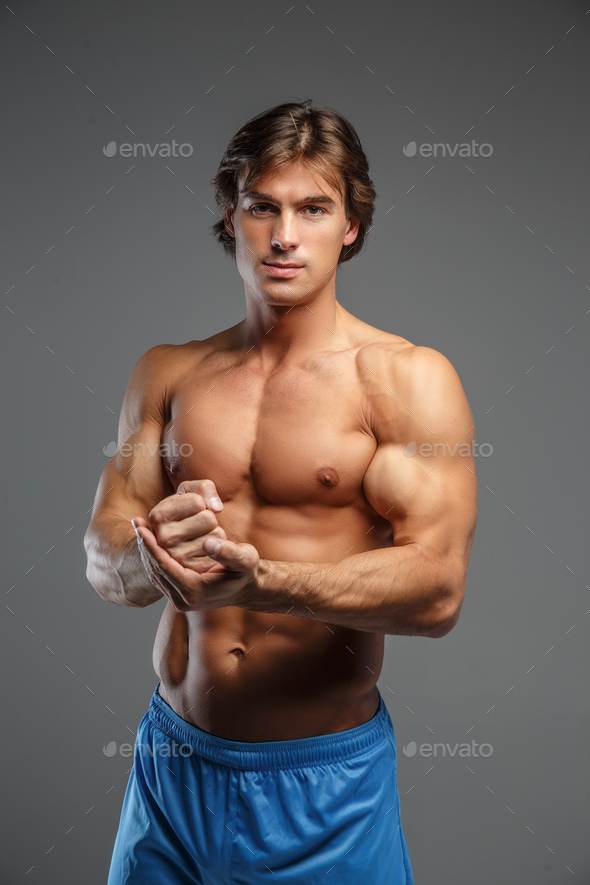 Half body portrait of muscular guy in blue shorts. Stock Photo by fxquadro