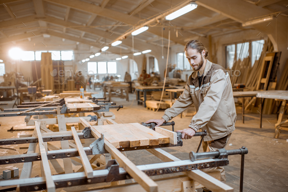 Carpenter working at the carpentry manufacturing Stock Photo by RossHelen