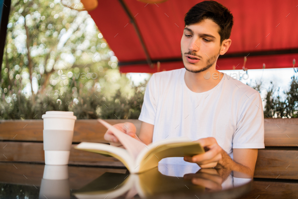 Man enjoying free time and reading a book. Stock Photo by megostudio