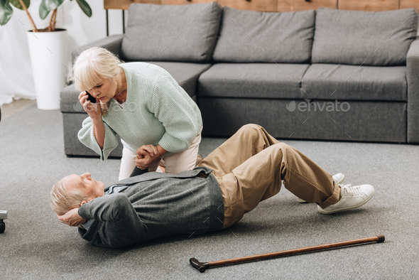senior woman holding hand of dying old man with walking stick Stock ...