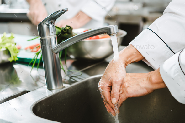 cropped view of female chef washing hands in restaurant kitchen Stock ...