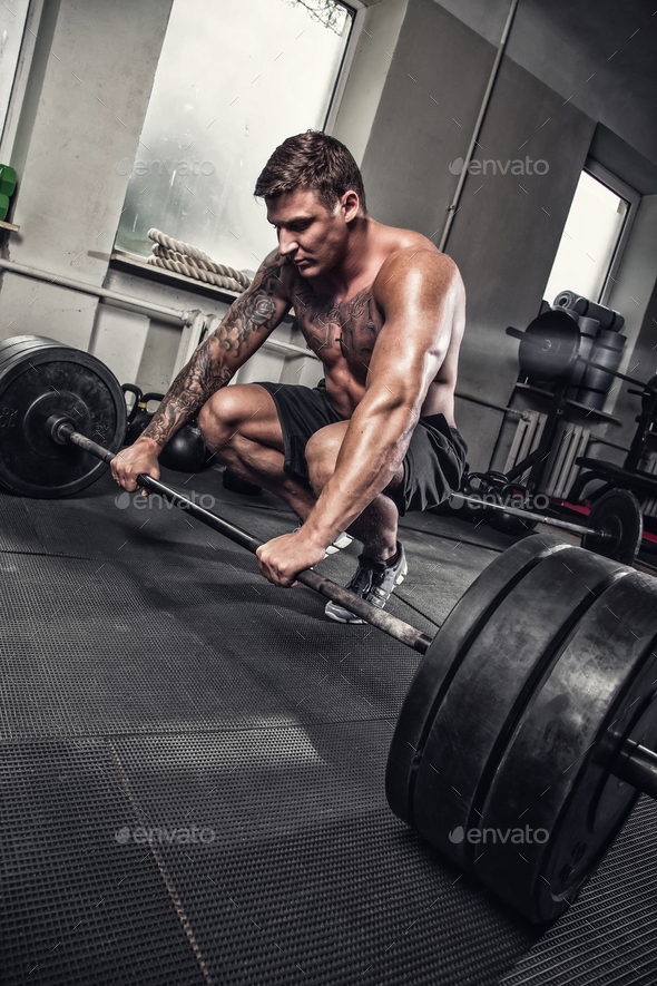 Tattooed muscular man standing on knees. Stock Photo by fxquadro ...