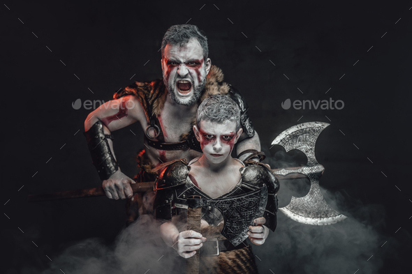 Screaming warrior poses with his son in dark background Stock Photo by ...