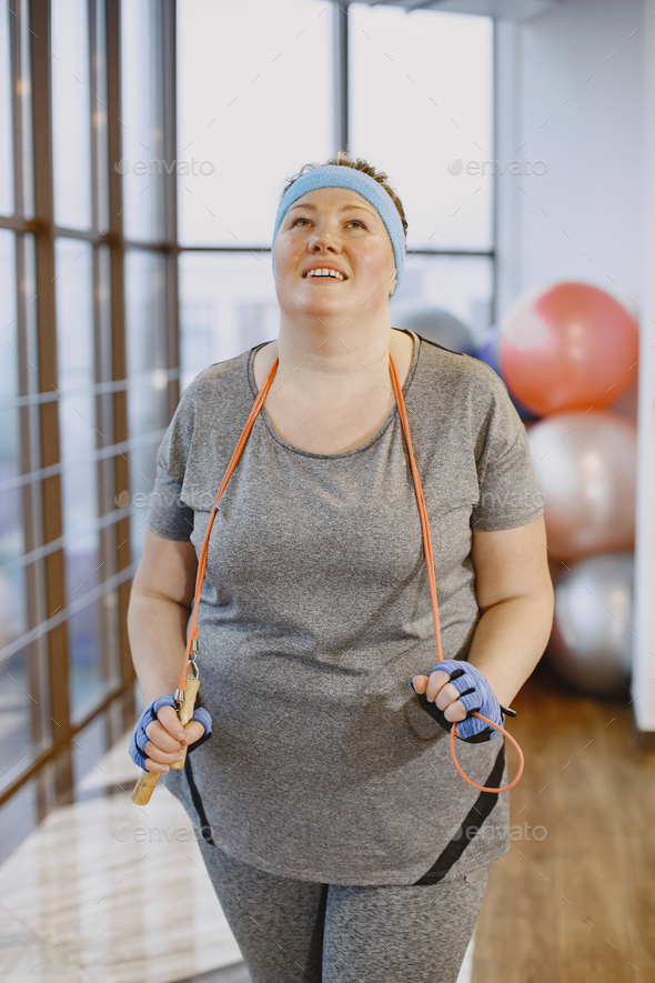 Adult fat woman doing gymnastics at the gym Stock Photo by prostooleh