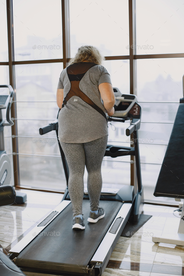 Adult fat woman doing gymnastics at the gym Stock Photo by prostooleh