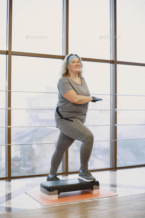 Adult fat woman doing gymnastics at the gym Stock Photo by prostooleh
