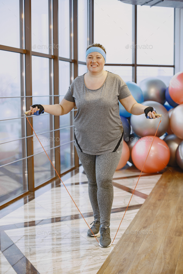 Adult fat woman doing gymnastics at the gym Stock Photo by prostooleh