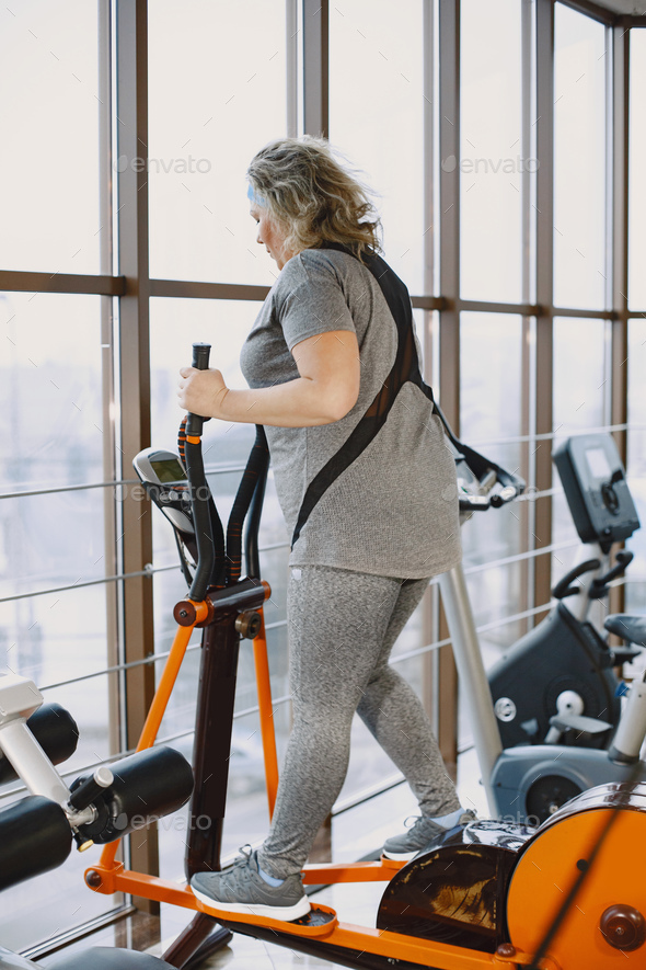 Adult fat woman doing gymnastics at the gym Stock Photo by prostooleh