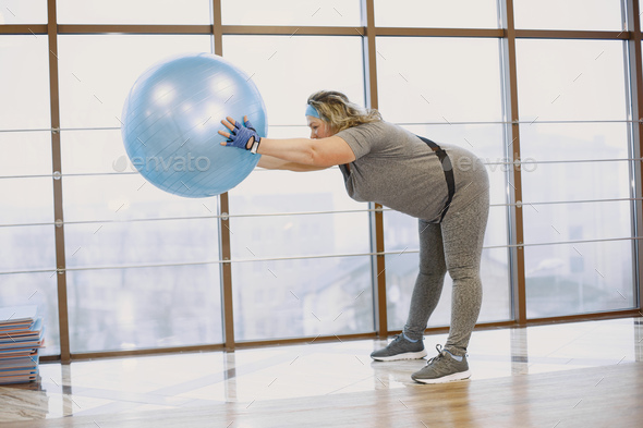 Adult fat woman doing gymnastics at the gym Stock Photo by prostooleh