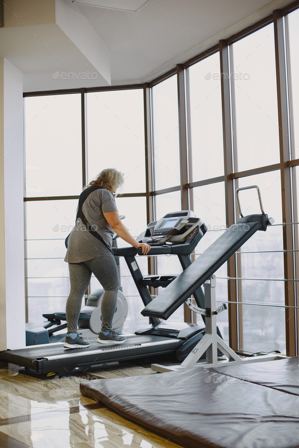 Adult fat woman doing gymnastics at the gym Stock Photo by prostooleh