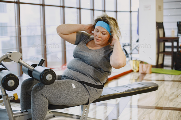 Adult fat woman doing gymnastics at the gym Stock Photo by prostooleh