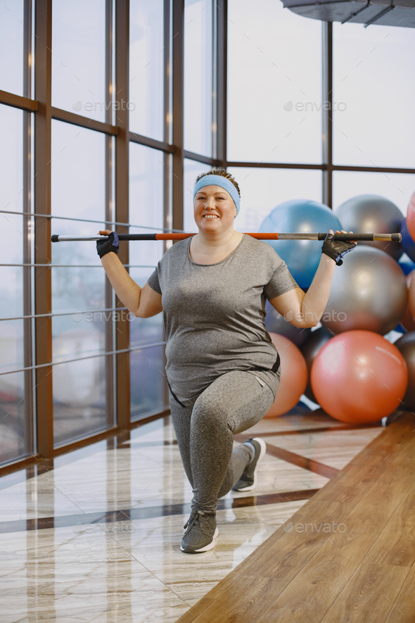 Adult fat woman doing gymnastics at the gym Stock Photo by prostooleh