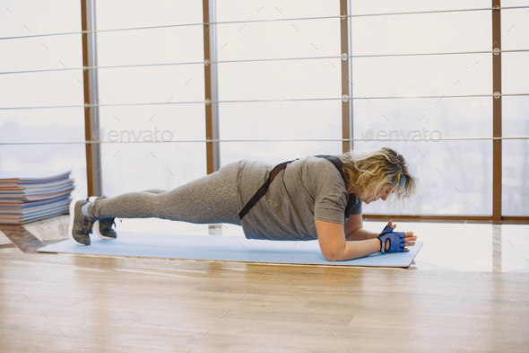Adult fat woman doing gymnastics at the gym Stock Photo by prostooleh