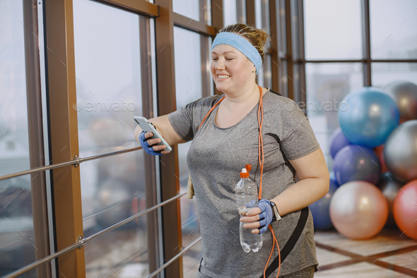 Adult fat woman doing gymnastics at the gym Stock Photo by prostooleh
