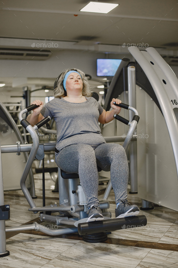 Adult fat woman doing gymnastics at the gym Stock Photo by prostooleh