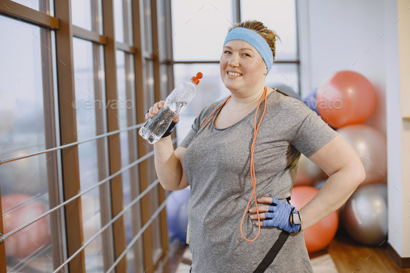 Adult fat woman doing gymnastics at the gym Stock Photo by prostooleh