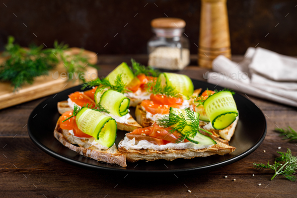 Toasts with salted salmon fish, ricotta cheese, fresh cucumber and ...
