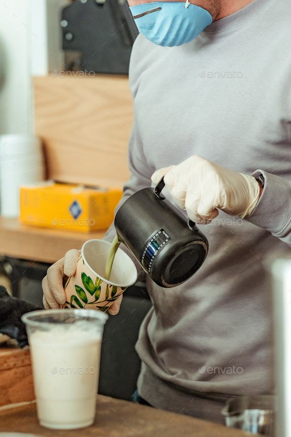 Barista at coffee shop wearing gloves and mask Stock Photo by JulyPI
