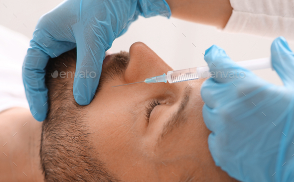 Closeup of middle-aged man getting nasolabial injection at clinic Stock ...