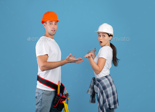 Concerned couple of workers man and woman shrugging over blue ...