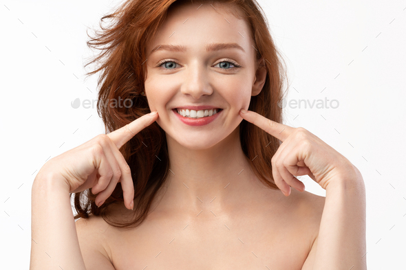 Red-Haired Young Lady Touching Dimples In Cheeks Smiling, White ...