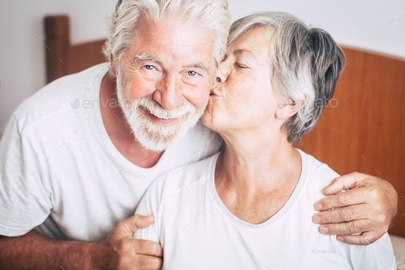 couple of seniors looking and smiling with love and affect while she's ...