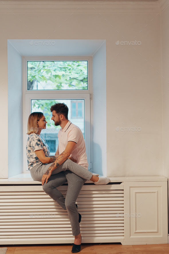 Couple in love sitting on the windowsill Stock Photo by diignat | PhotoDune
