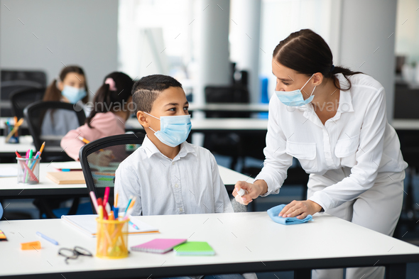 Teacher cleaning table with antibacterial sanitizer and napkin Stock ...