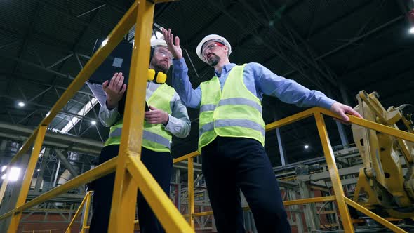 Workers Stand in a Factory Interior, Checking Equipment., Stock Footage