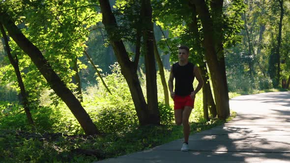 Slow Motion Runner in Sunlit Park, Stock Footage | VideoHive