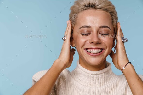 Happy beautiful blonde girl smiling and covering her ears Stock Photo ...