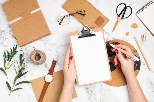 Desktop with woman hands holding clipboard and recyclable office ...