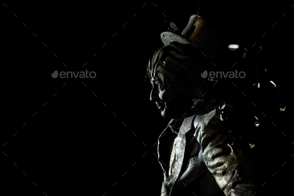 Side view of mime imitating statue on black background Stock Photo by ...