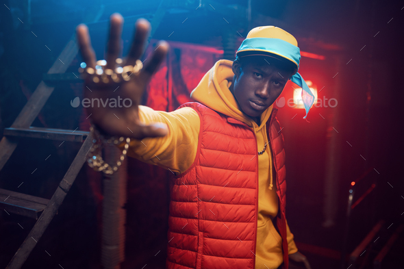 Young serious rapper poses in grunge studio Stock Photo by NomadSoul1