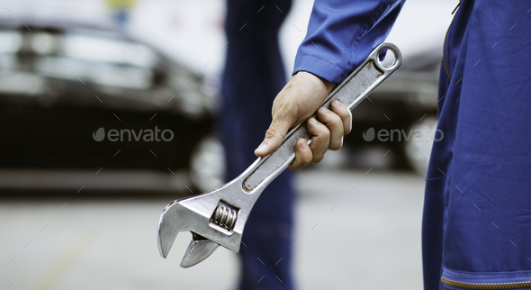 Mechanic man hand holding wrench in auto repair shop Stock Photo by ...
