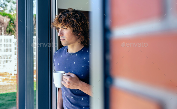 Man drinking coffee leaning against the window frame Stock Photo by ...