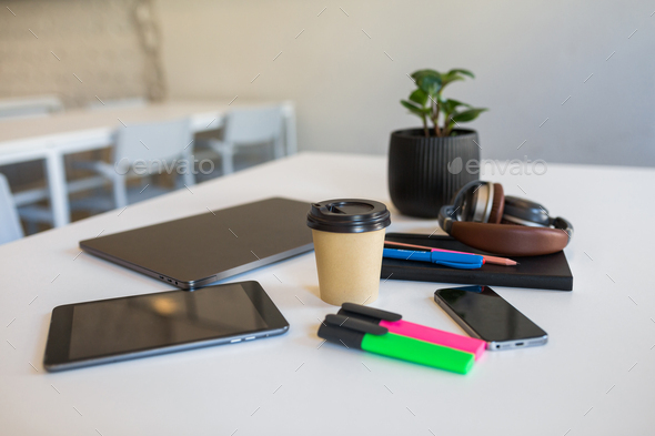 different office stationery arranged on white table in co-working ...