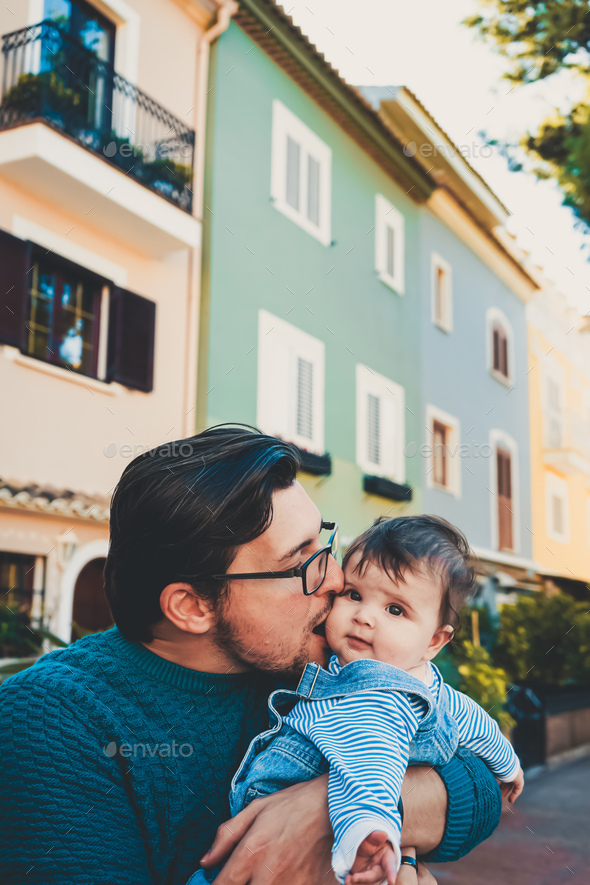 Adorable portrait of a young father hugging his baby Stock Photo by nanihta