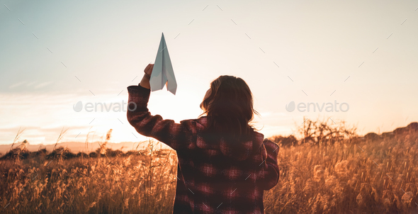 Traveling woman with paper airplane flying at the land at sunset. Stock ...